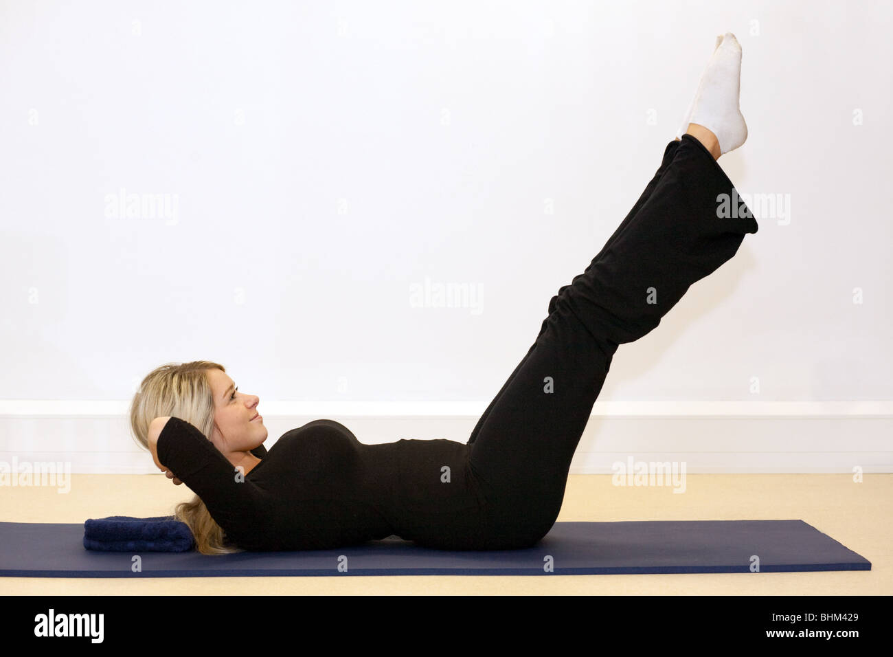 Blonde teenage girl doing Pilates stretching exercises Stock Photo - Alamy