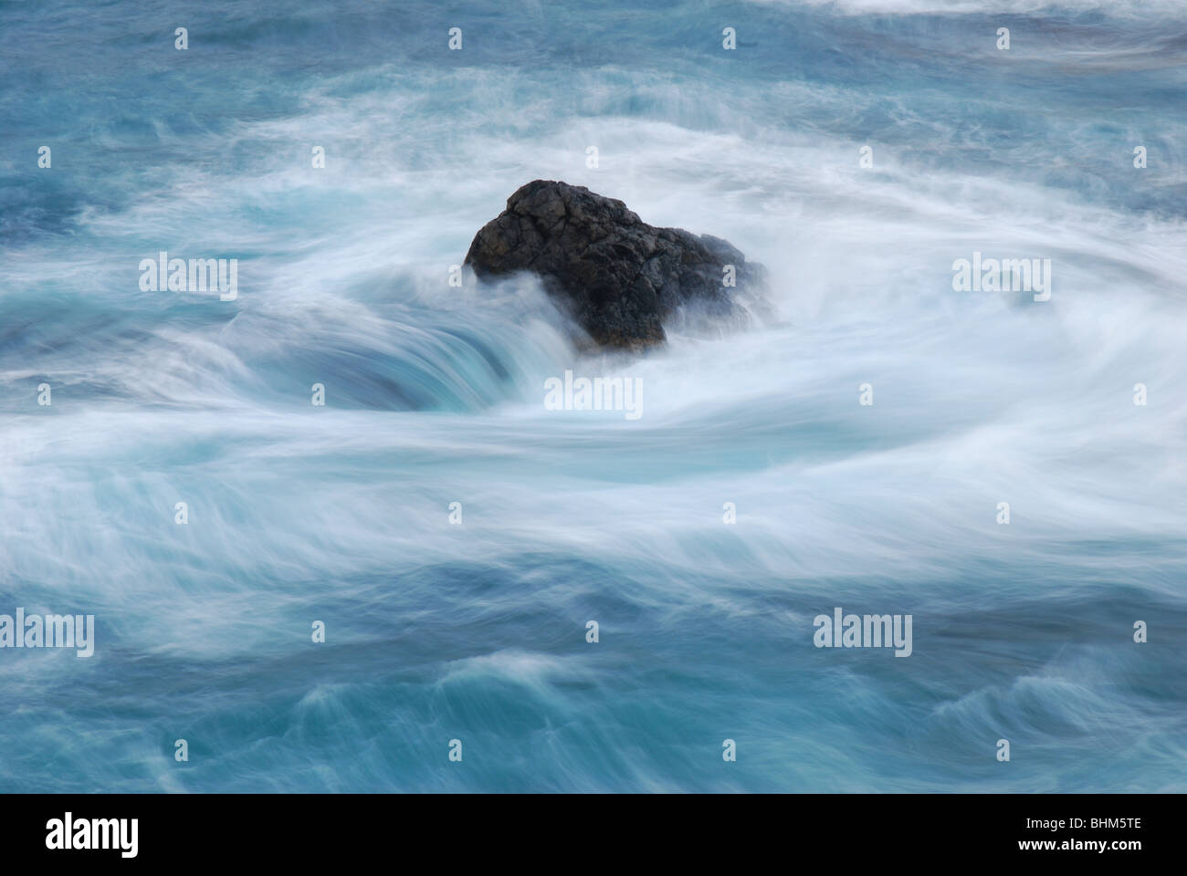 Swirling sea, Waves round a rock Stock Photo - Alamy
