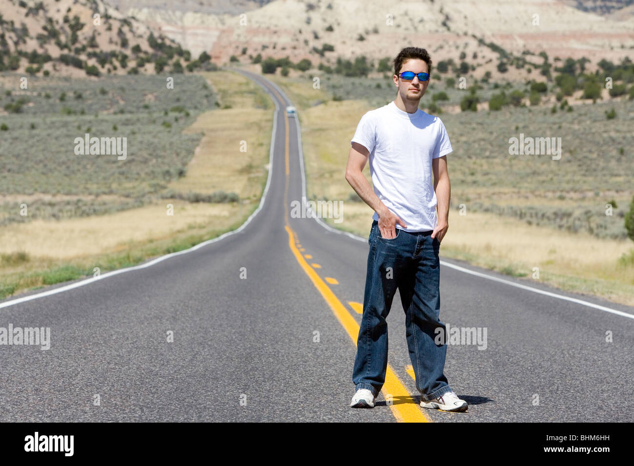 Young Man standing on stretch of empty highway road in Utah Stock Photo ...