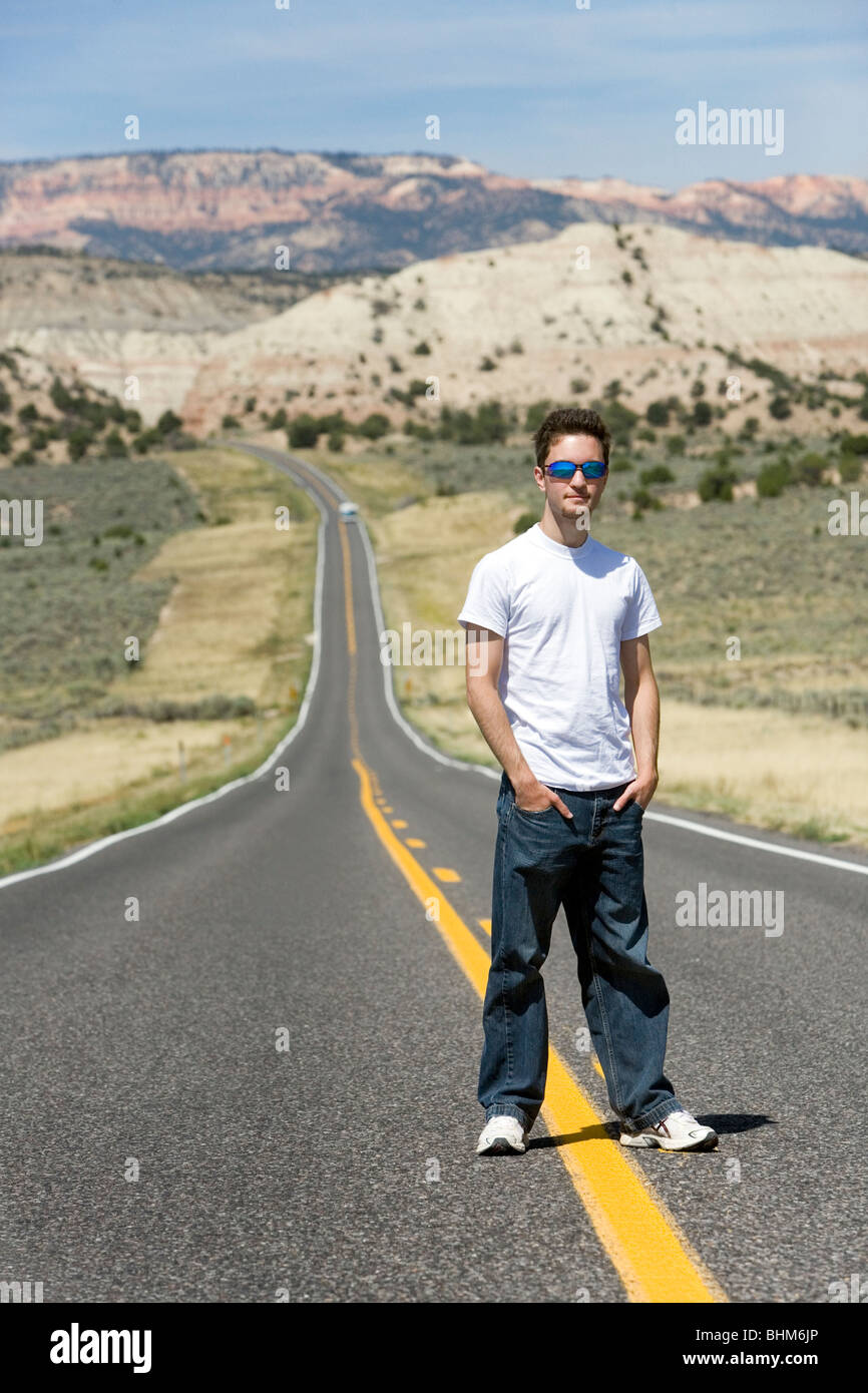 Young Man standing on stretch of empty highway road in Utah Stock Photo ...