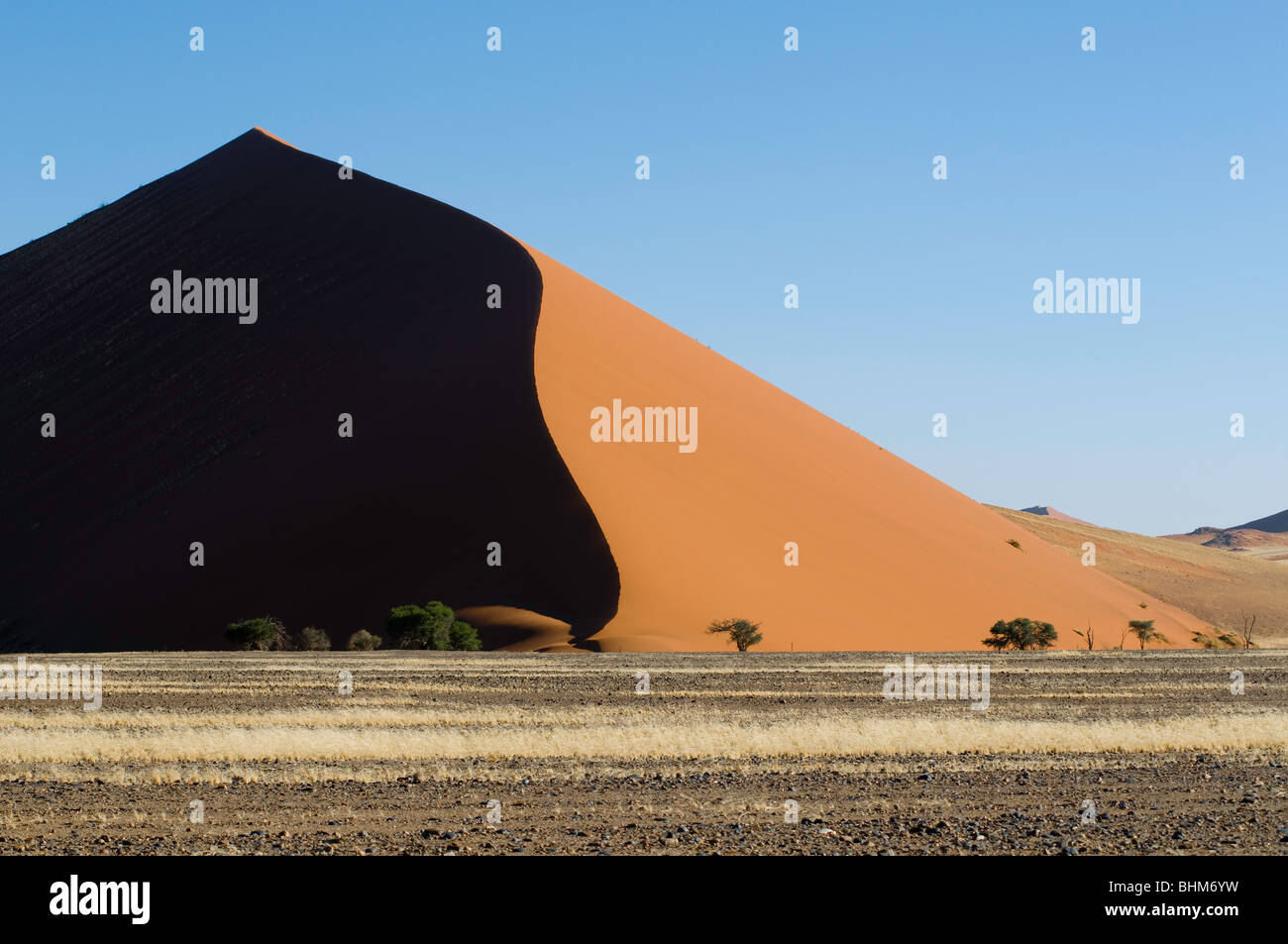 Red "star dune" in Namib desert, Namibia, Africa. S-shaped shadow. Dry ...