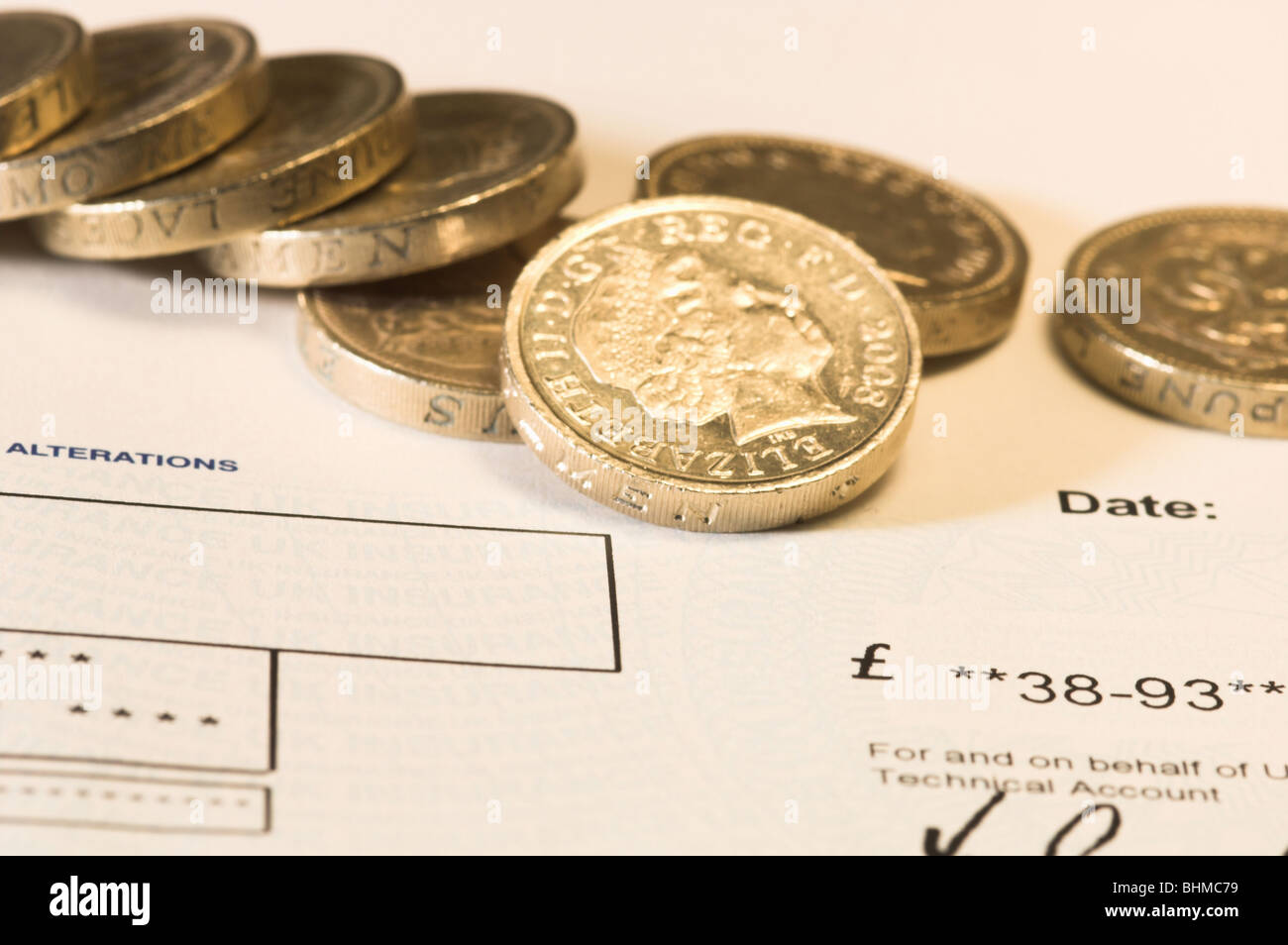 Pound coins on a cheque Stock Photo - Alamy