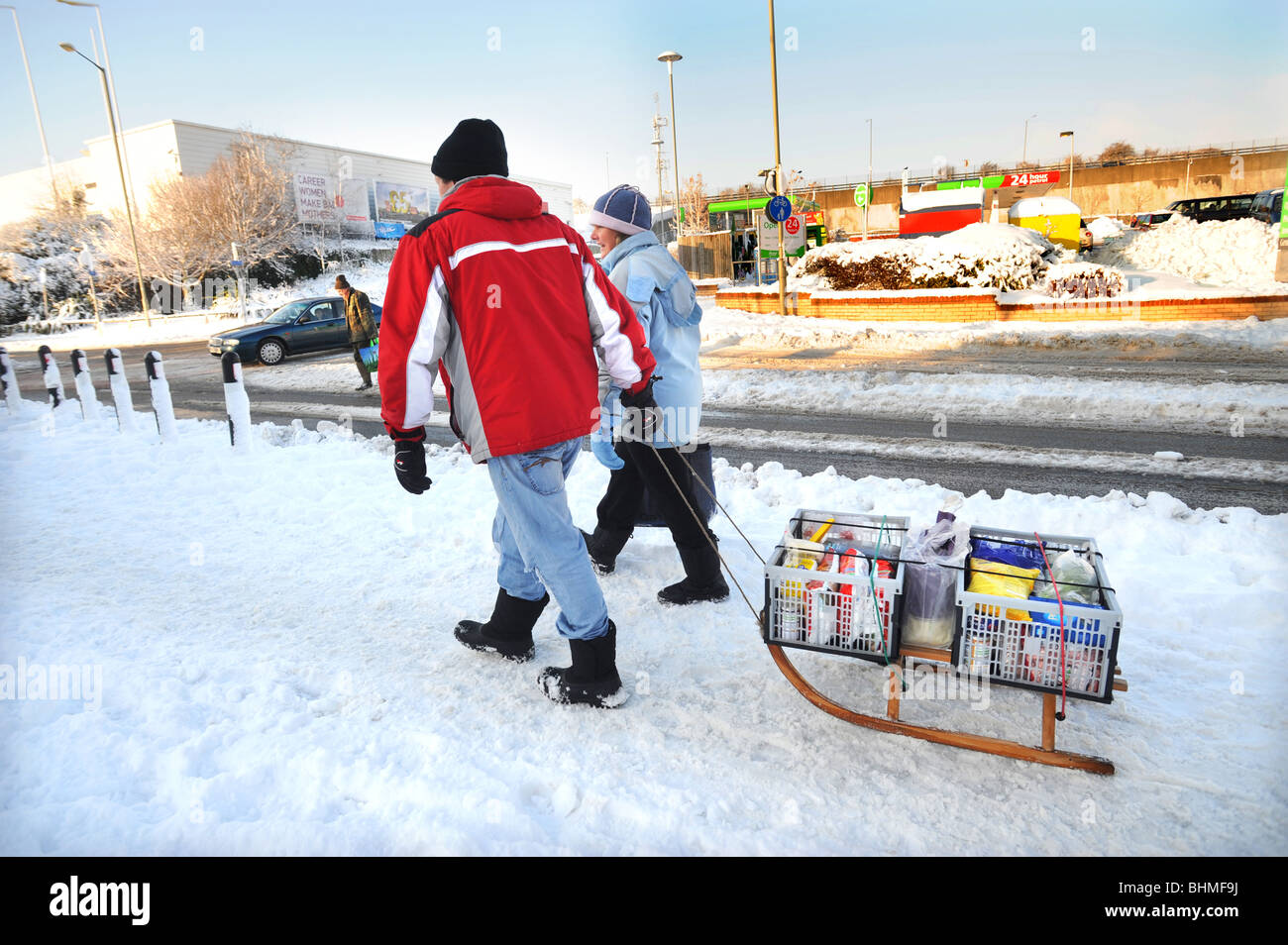 A couple use a sledge to take home their shopping from the supermarket ...
