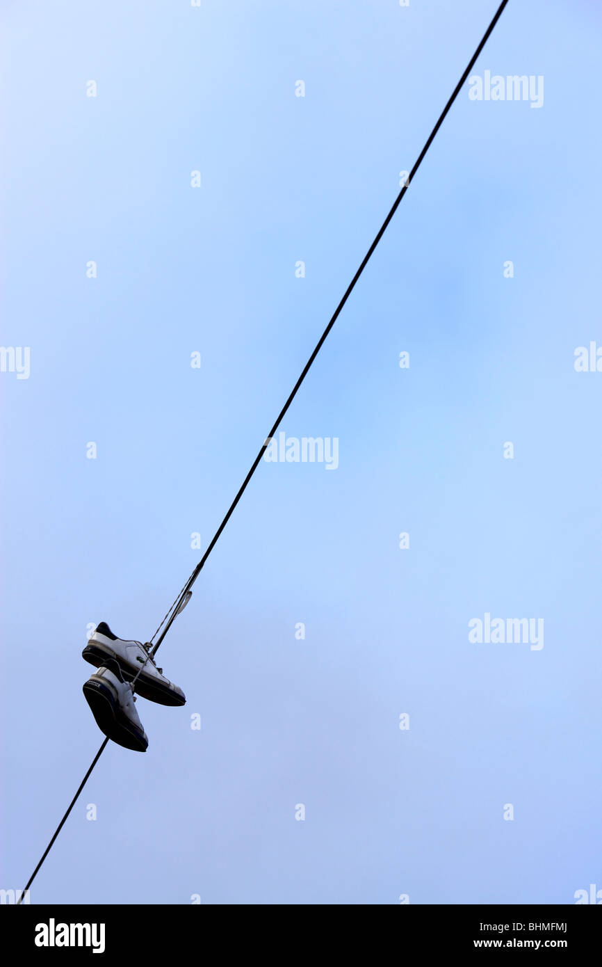 A pair of trainers shoes hanging off a telephone wire Stock Photo - Alamy