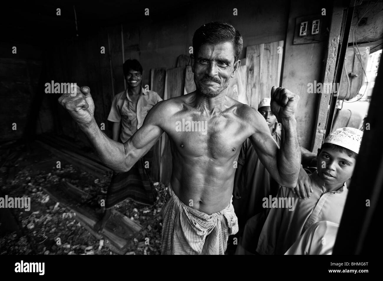 A muslim woodworker in Barisal Bangladesh shows off his muscles from ...