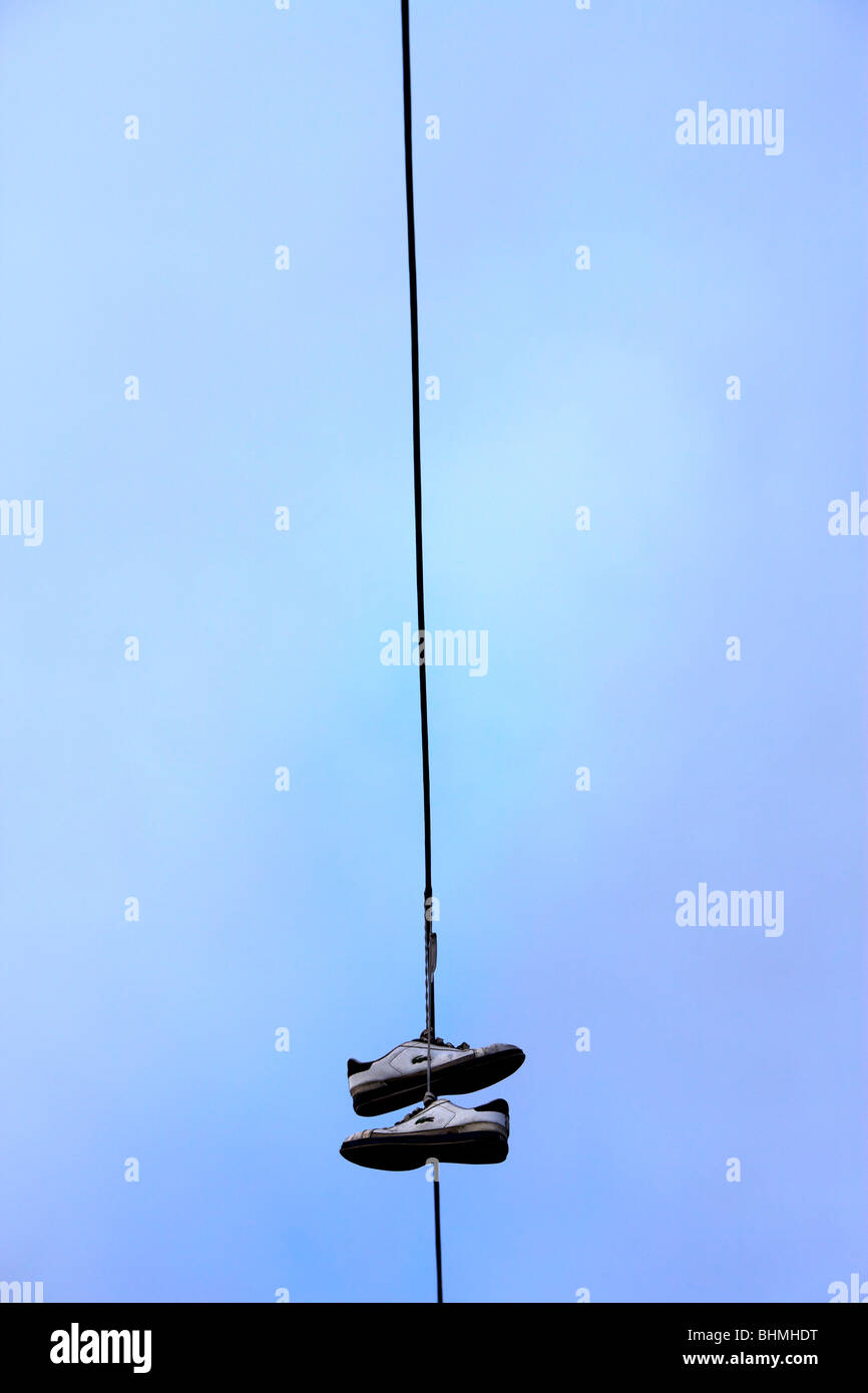 A pair of trainers shoes hanging off a telephone wire Stock Photo - Alamy