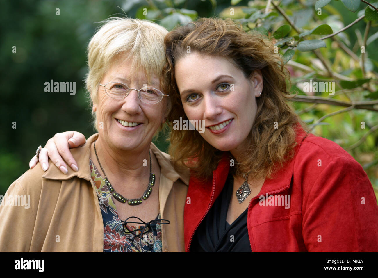 Senior mother with her grown up daughter in garden posing and facing ...