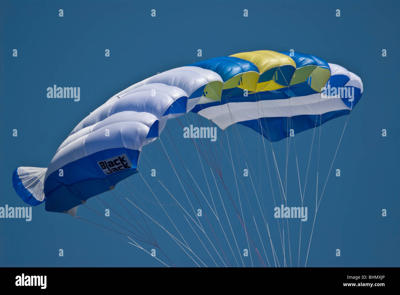 A yellow white, and blue parachute against a blue sky during Bridge Day ...