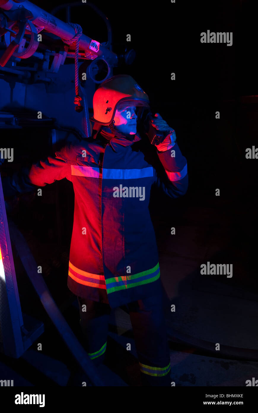 Fireman in blue flashing light at night Stock Photo - Alamy