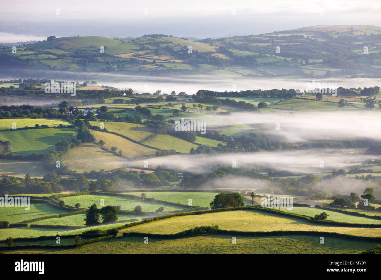 Mist covered farmland at dawn surrounding the village of Capel Gwynfe ...
