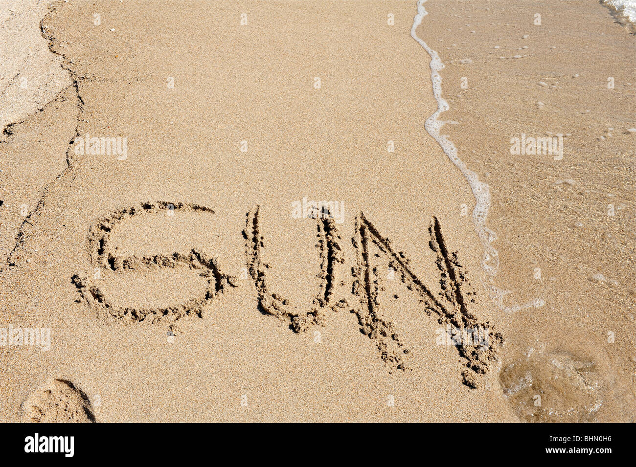 The word sun written in the sand on the beach Stock Photo - Alamy