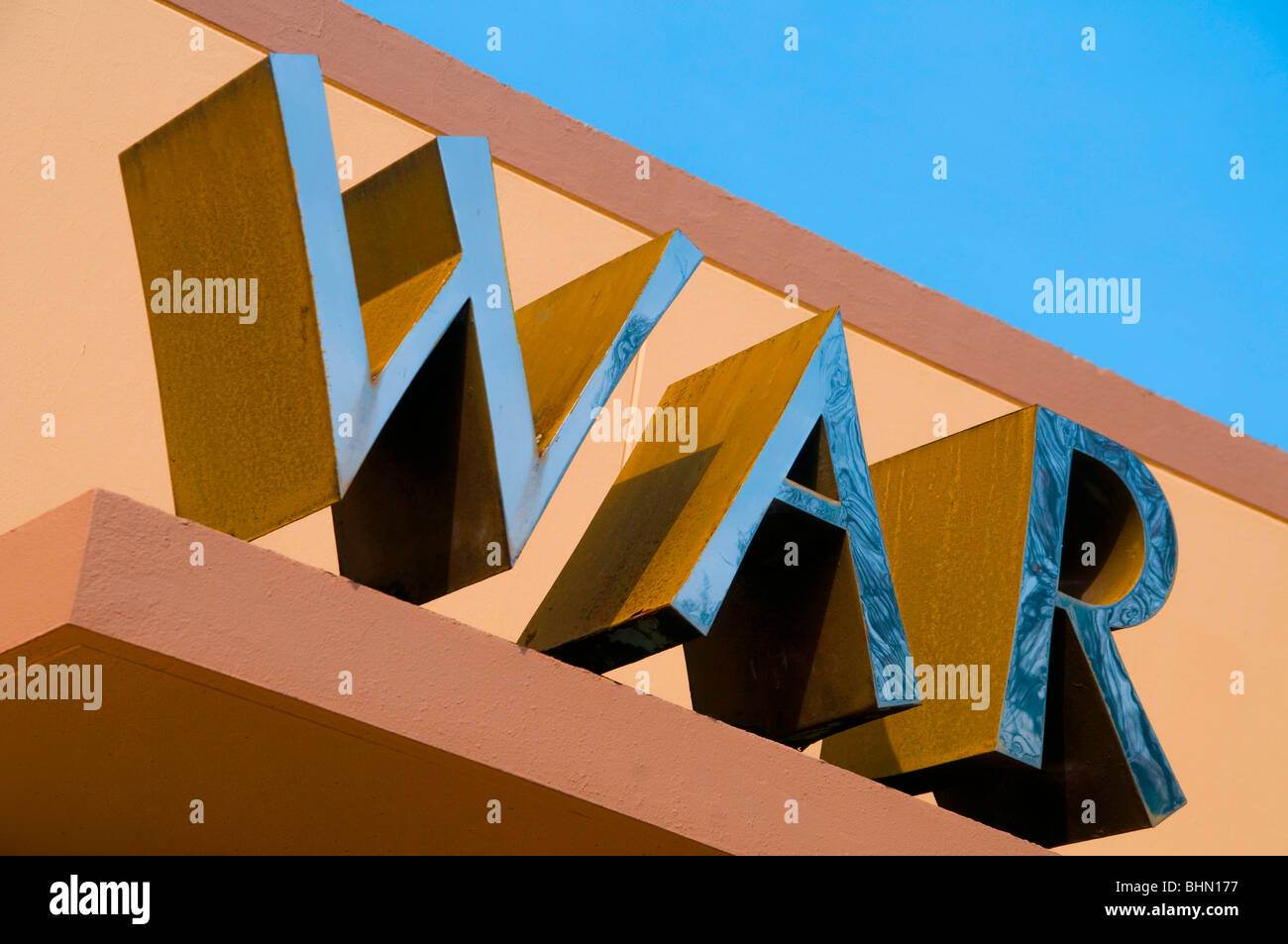Chrome art deco lettering on a war memorial spelling out the word "War ...