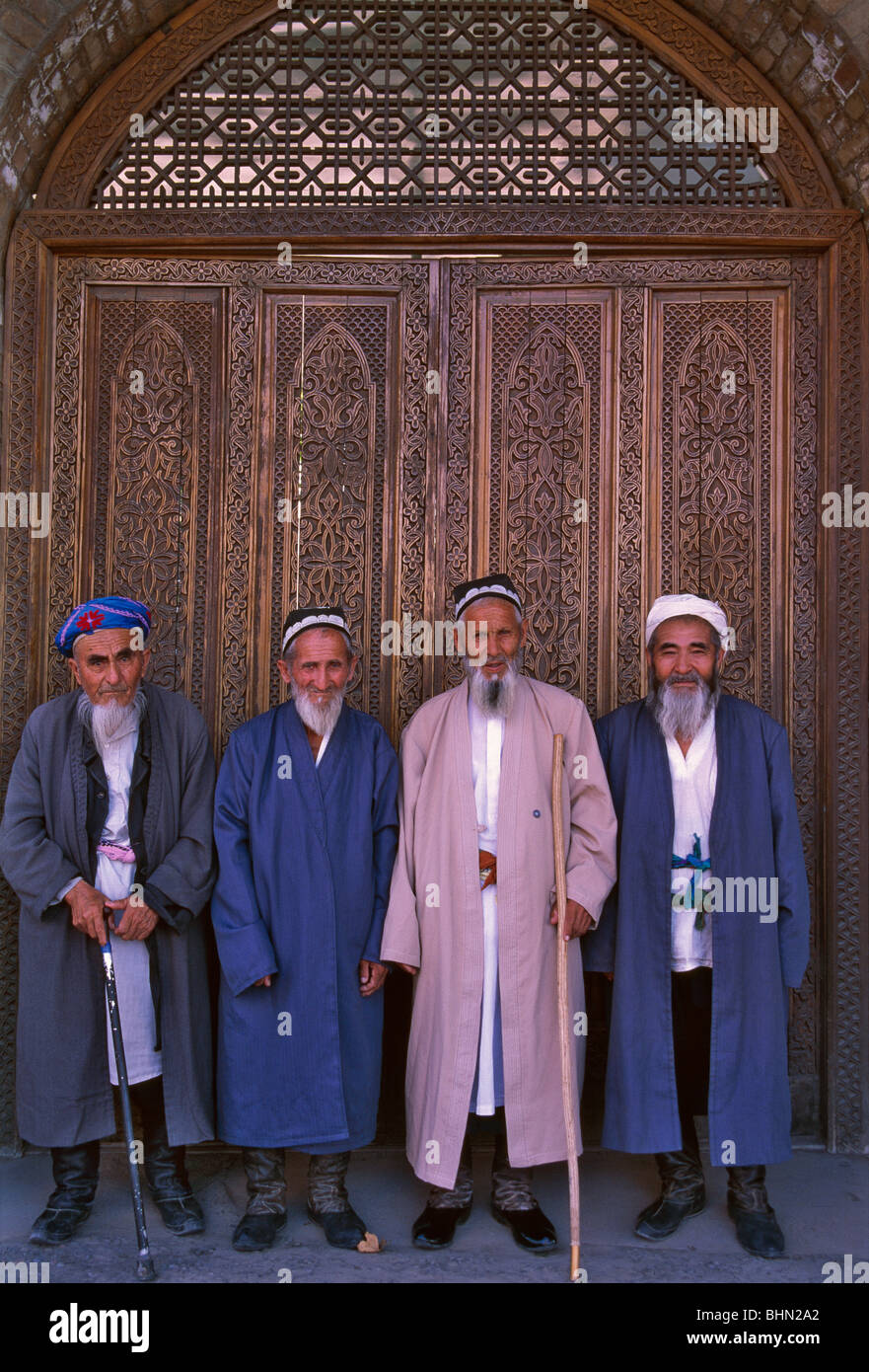 Uzbek men in traditional costume by a wood gate, Tashkent, Uzbekistan ...