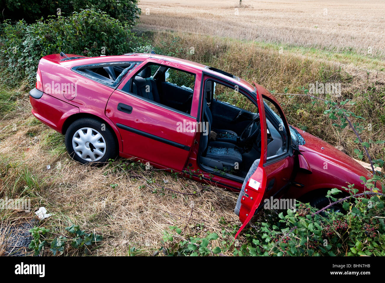 Abandoned car dumped in ditch and deliberately damaged Stock Photo - Alamy