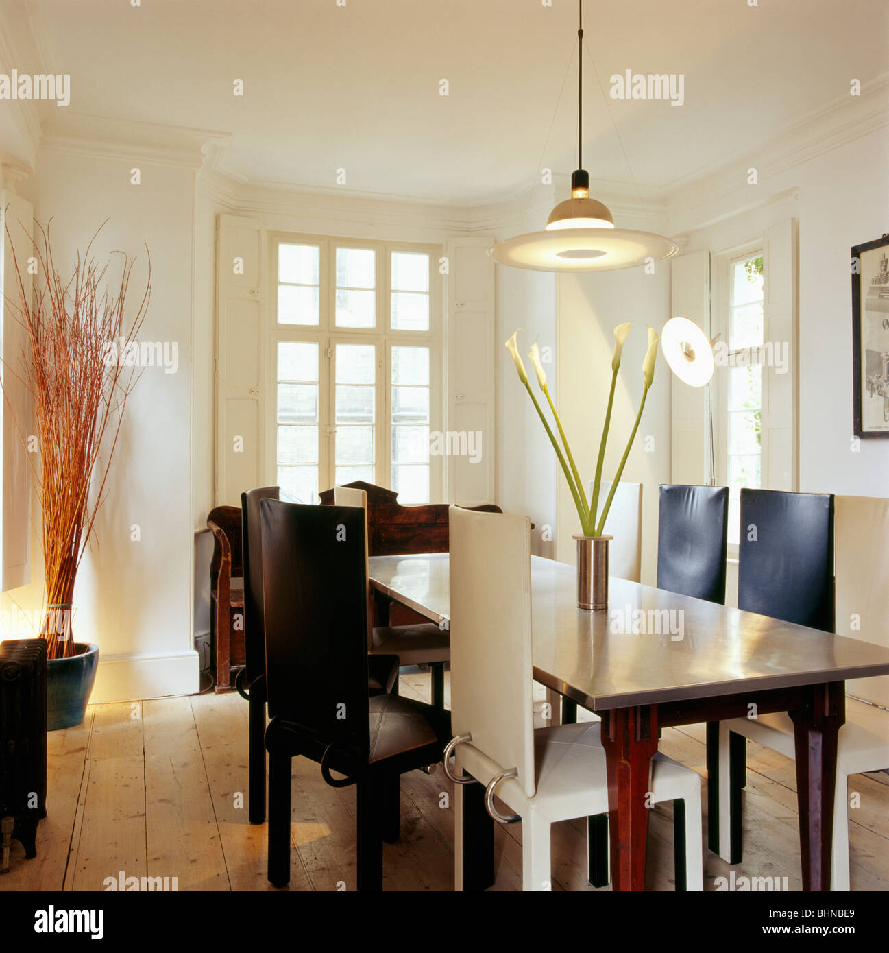 Lighted ceiling lamp above black and white chairs and stainless steel ...