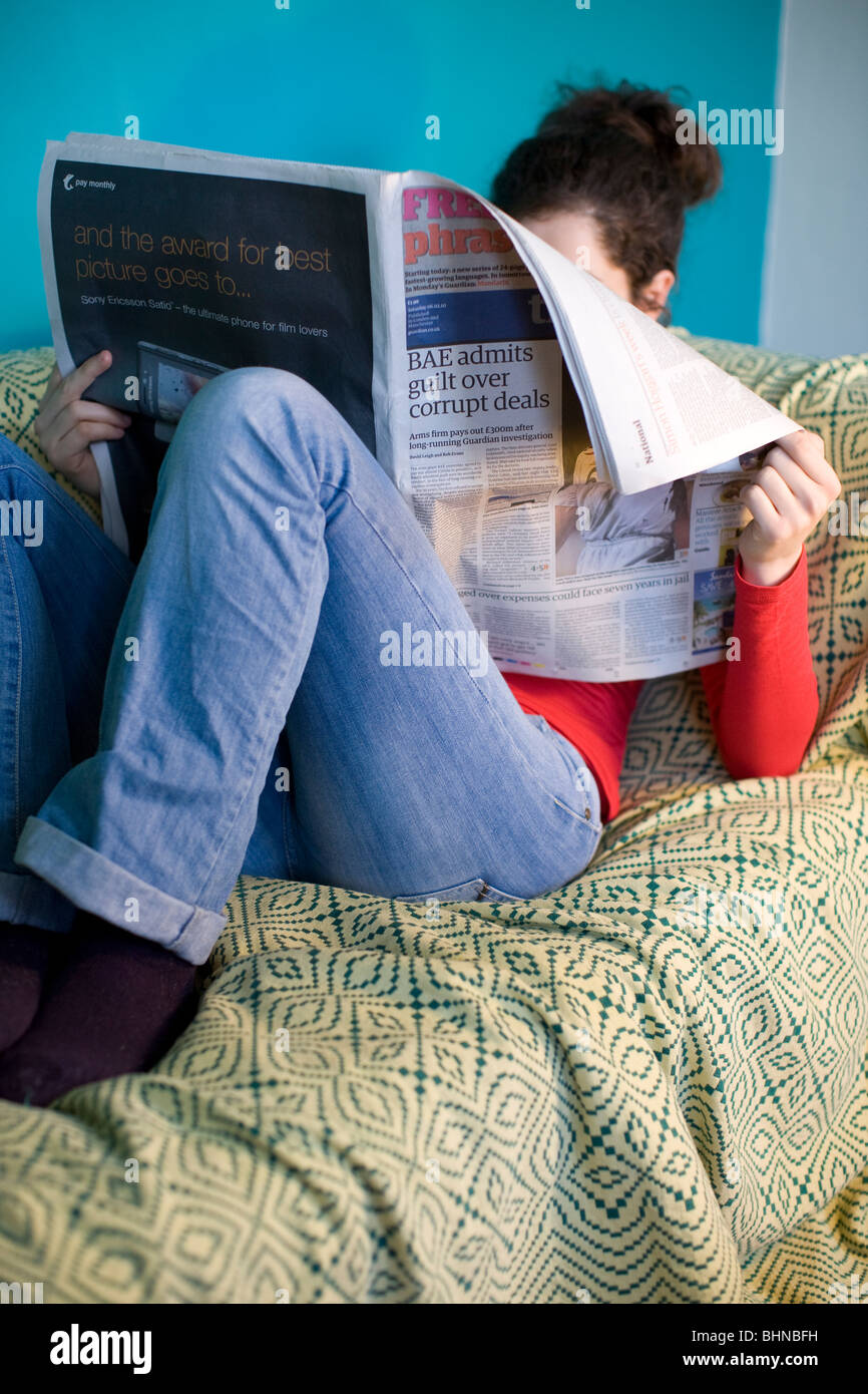 Young woman reading newspaper, London - Model Released Stock Photo - Alamy