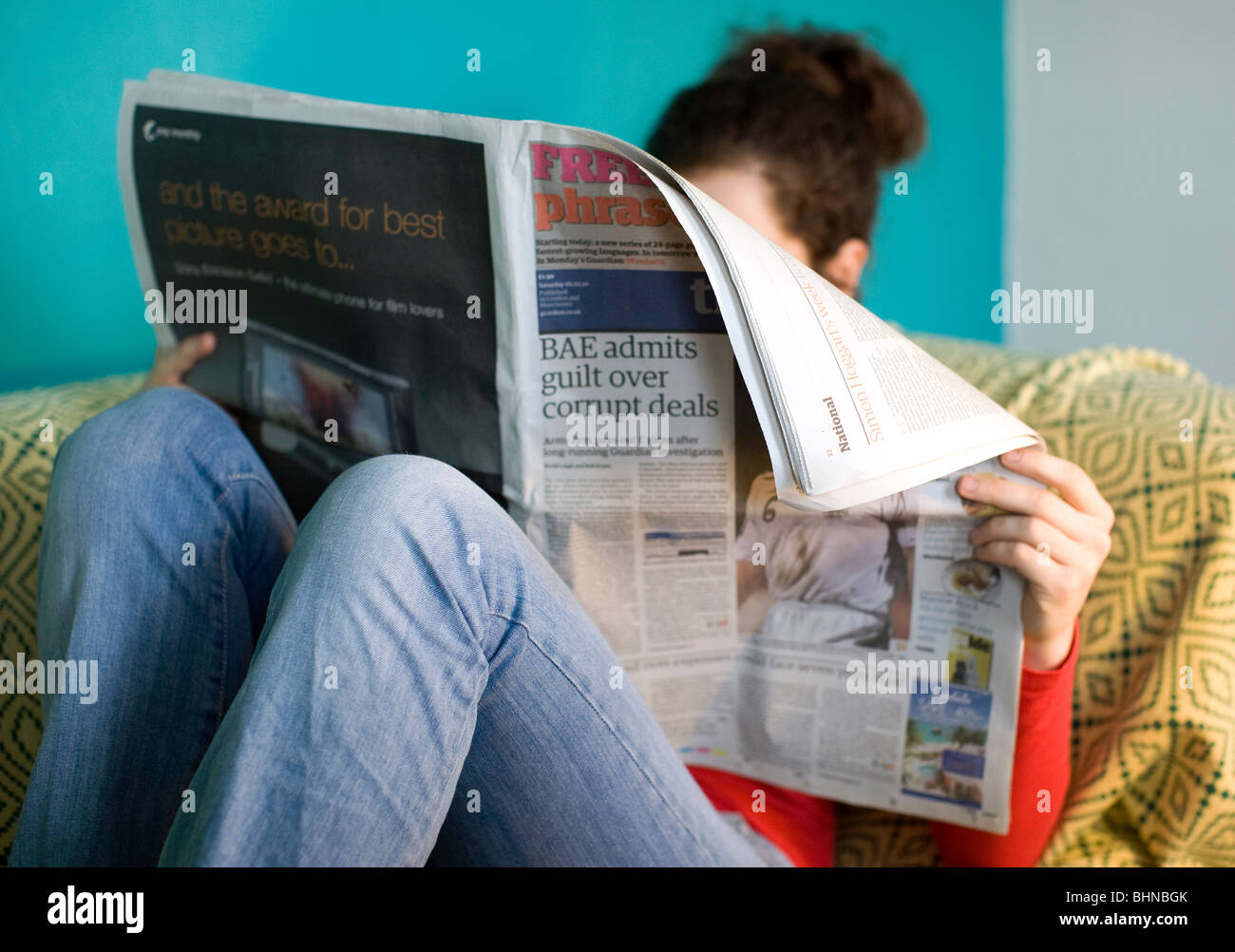 Young woman reading newspaper, London - Model Released Stock Photo - Alamy