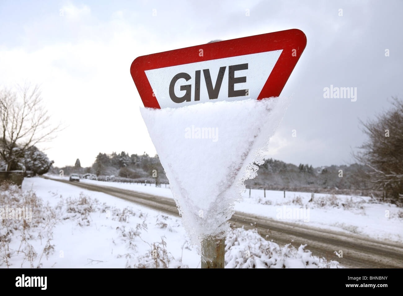 Give way sign in the snow Stock Photo - Alamy