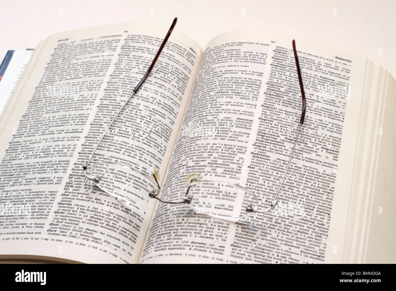 Dictionary with reading glasses Stock Photo - Alamy
