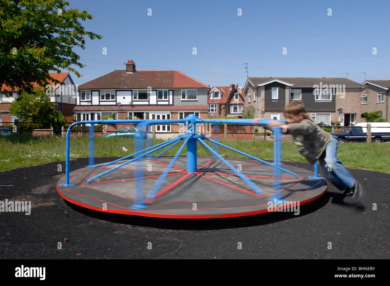 Boy playing on a roundabout hi-res stock photography and images - Alamy