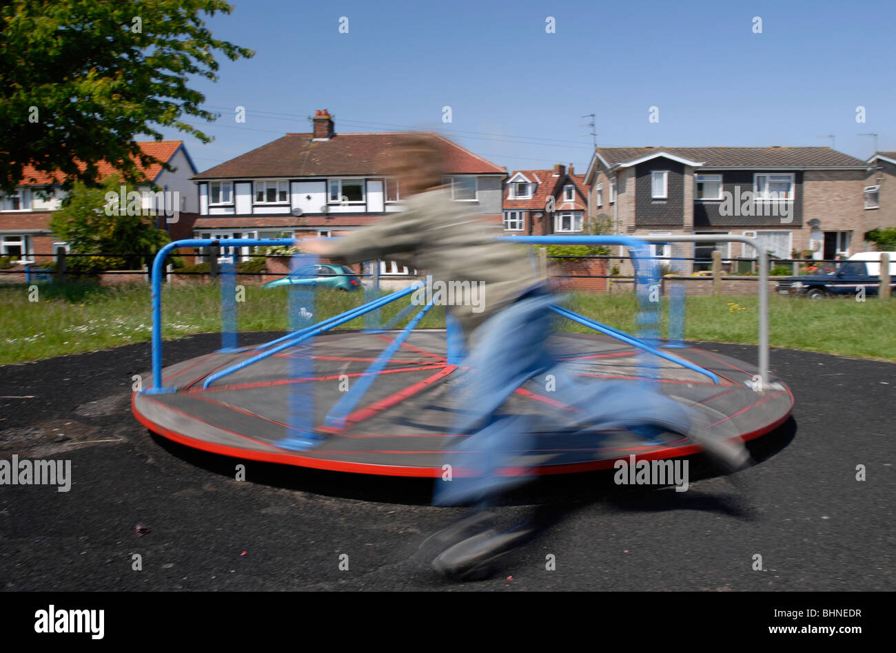 Boy playing on a roundabout Stock Photo - Alamy