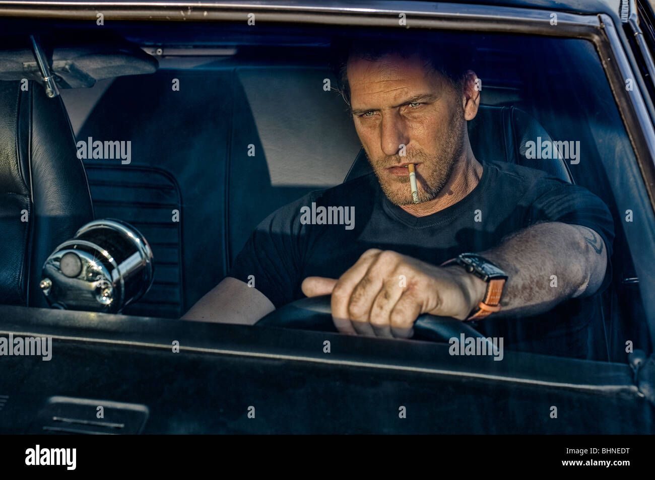Man driving vintage black car and smoke cigarette Stock Photo - Alamy