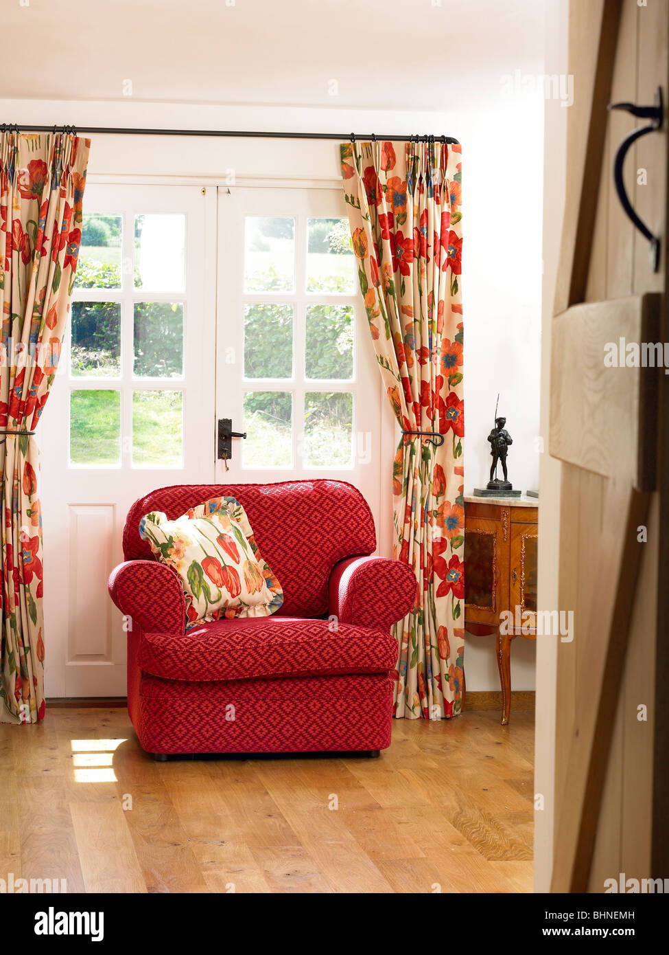 A red comfy chair by a door Stock Photo - Alamy