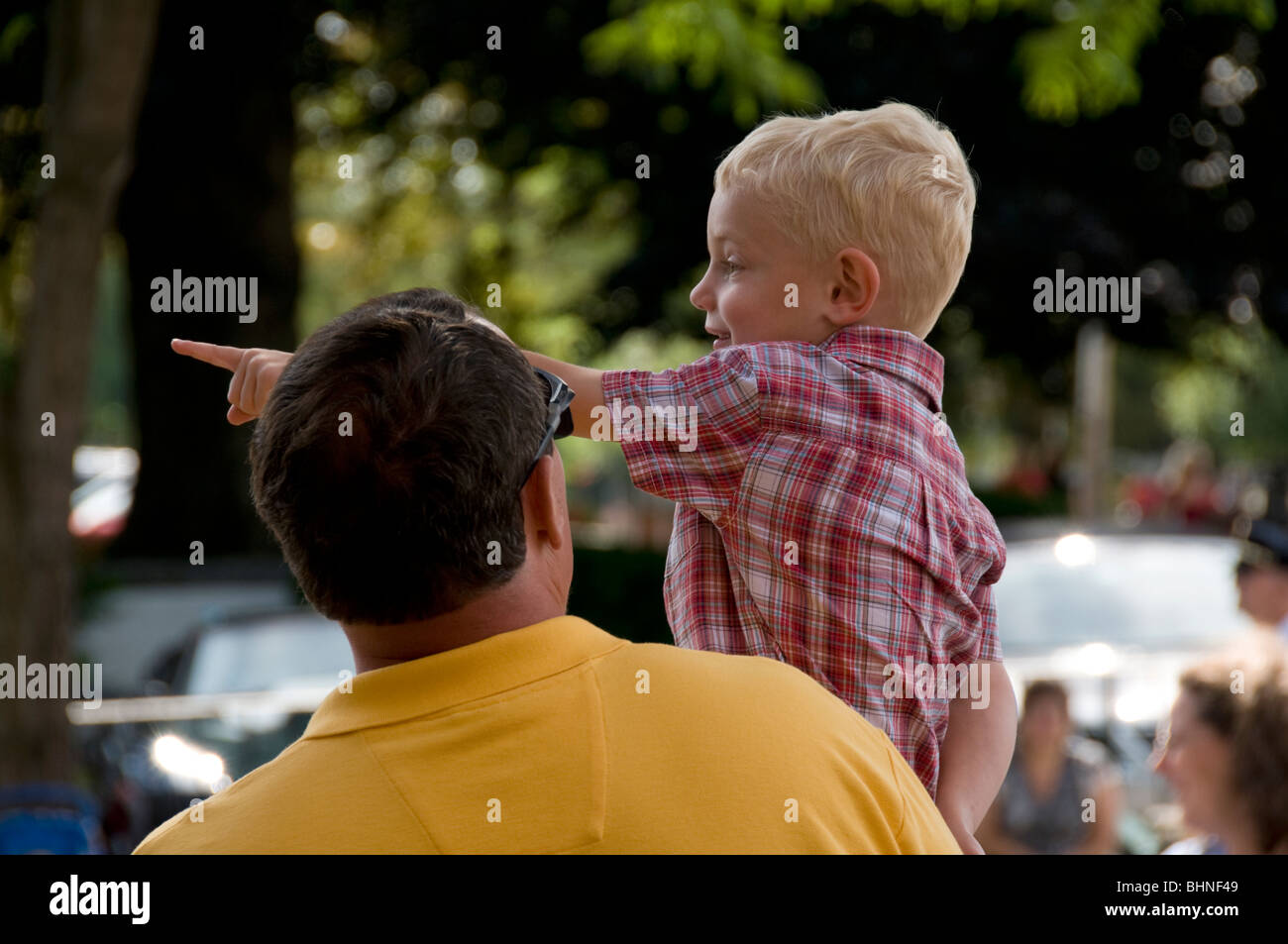 Father raising son for better view of parade Stock Photo - Alamy