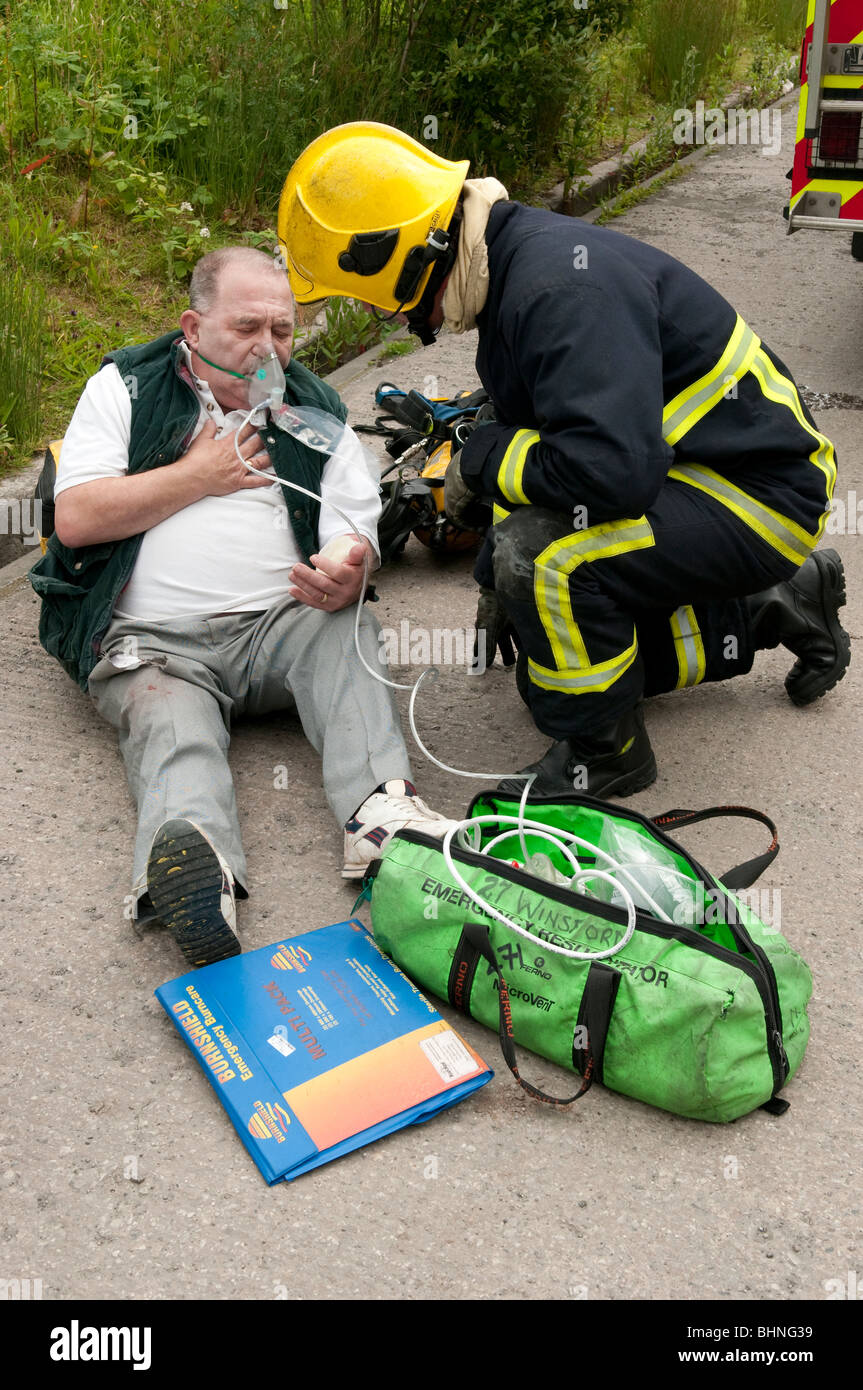 Fireman gives first aid to casualty - simulation Stock Photo - Alamy
