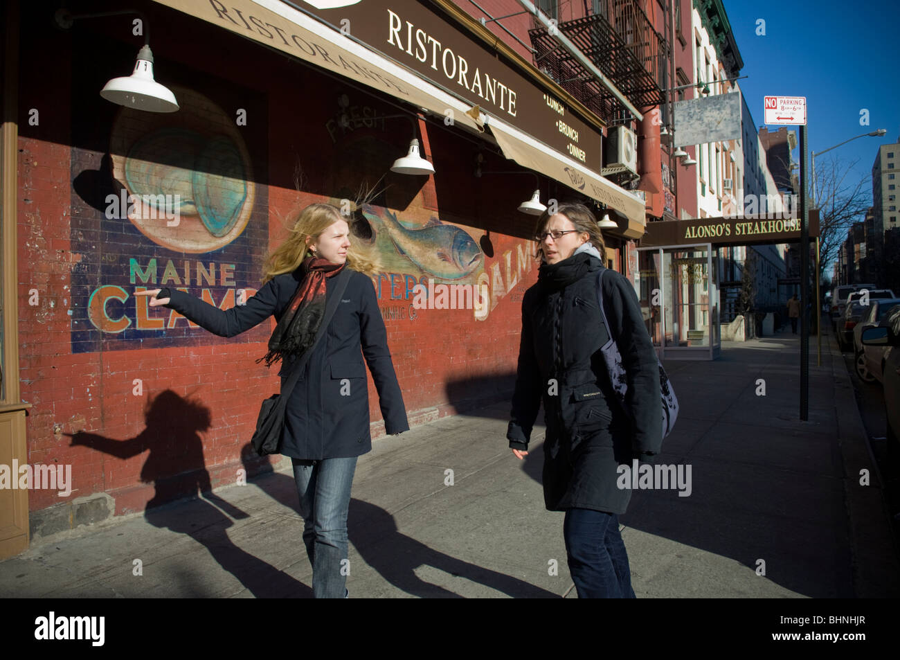 Pedestrians pass a mural on the exterior wall of the Tello Restaurant ...
