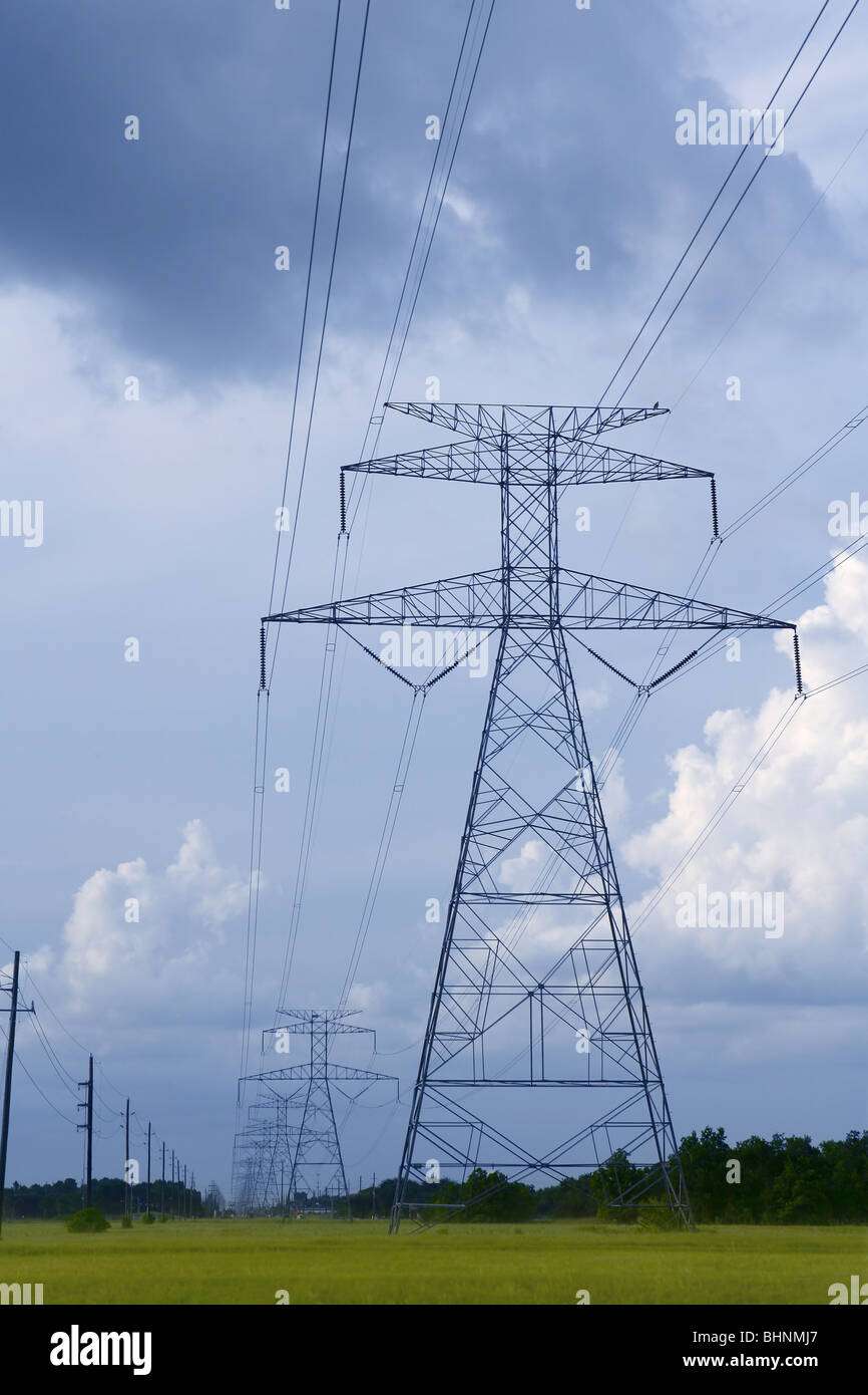 Electric tower poles on a green meadow over sky Stock Photo - Alamy