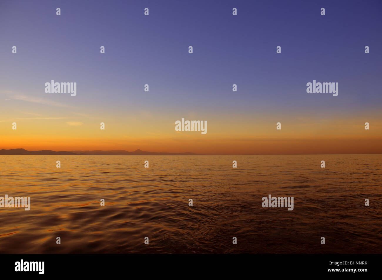 Beautiful sunset sunrise over blue sea ocean in red sky Stock Photo - Alamy