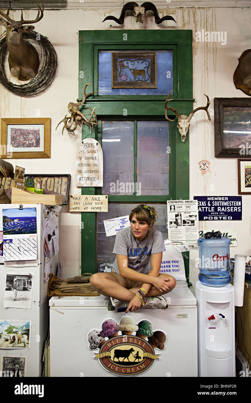 Girl sitting on freezer in ice cream parlour and soda fountain in ...