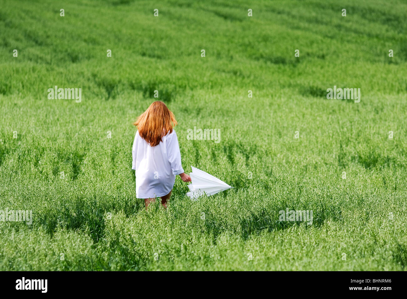 Young woman walking in a field Stock Photo - Alamy