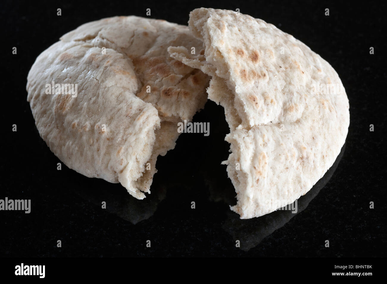 Single Pitta bread on a dark marble surface Stock Photo - Alamy