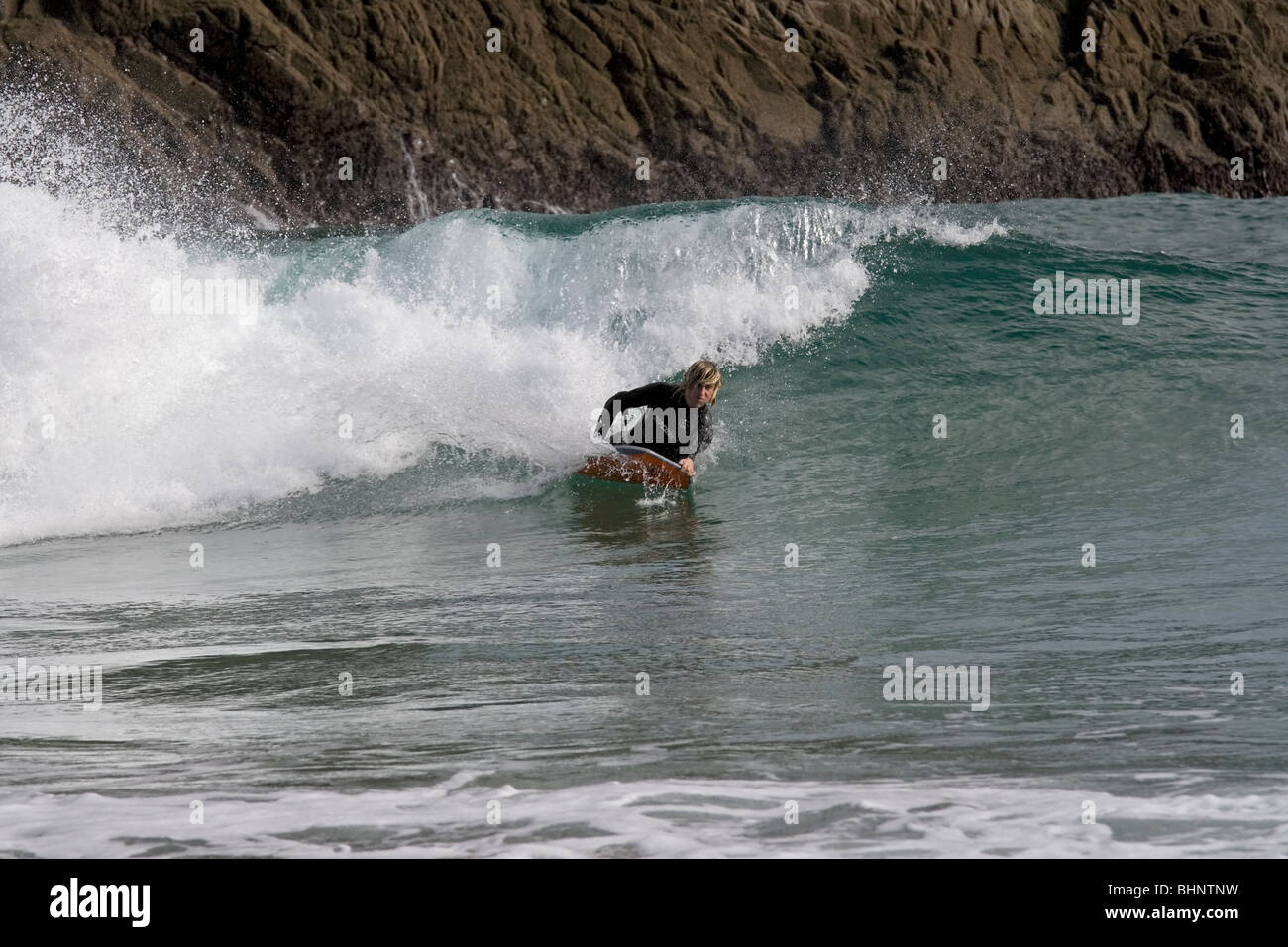 Body boarding or short boarding, riding a wave; Kynance Cove, Cornwall ...