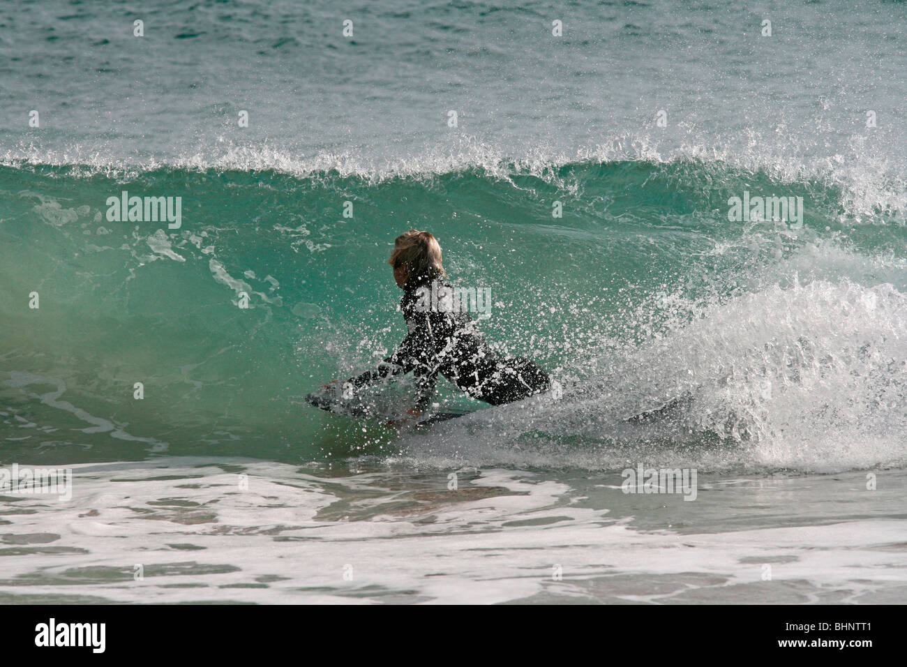 Body boarding or short boarding, riding a wave; Kynance Cove, Cornwall ...