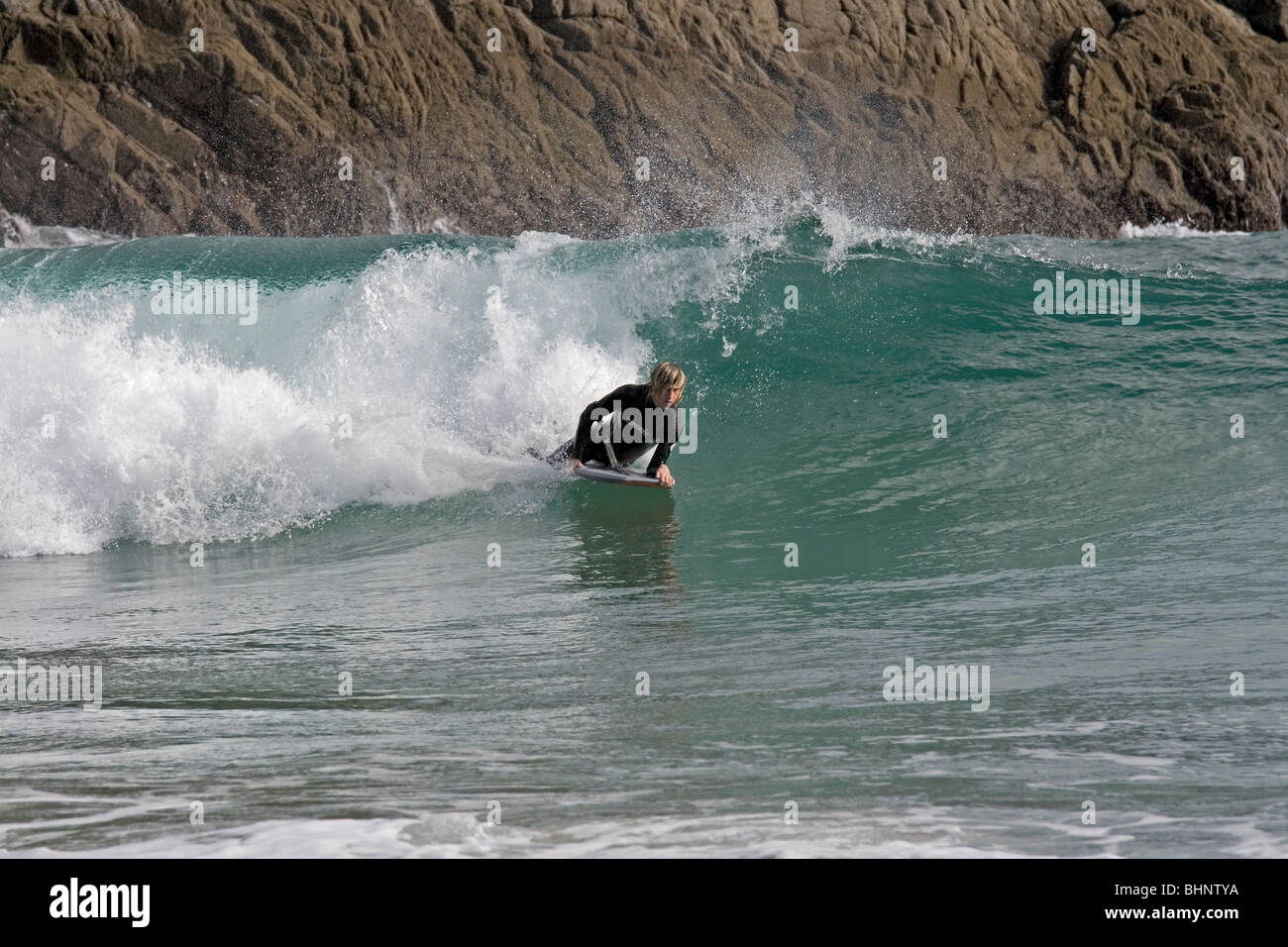 Body boarding or short boarding, riding a wave; Kynance Cove, Cornwall ...