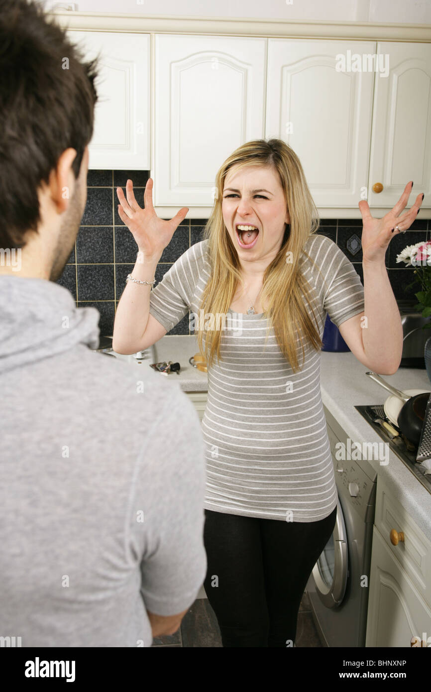 Young couple standing talking / arguing in a kitchen Stock Photo - Alamy
