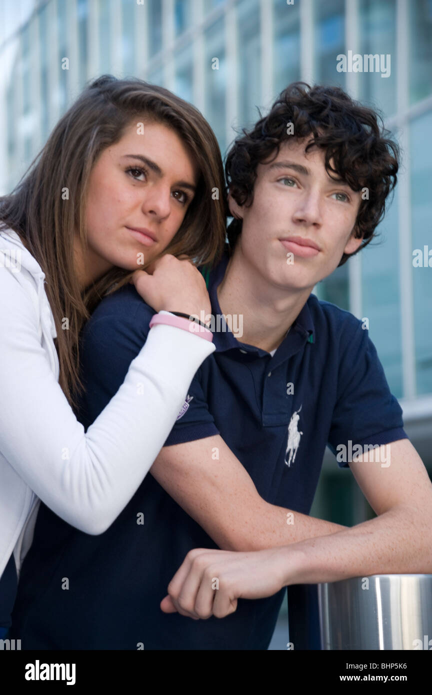 Teenage couple she leans on him they both look off moodily. Model ...