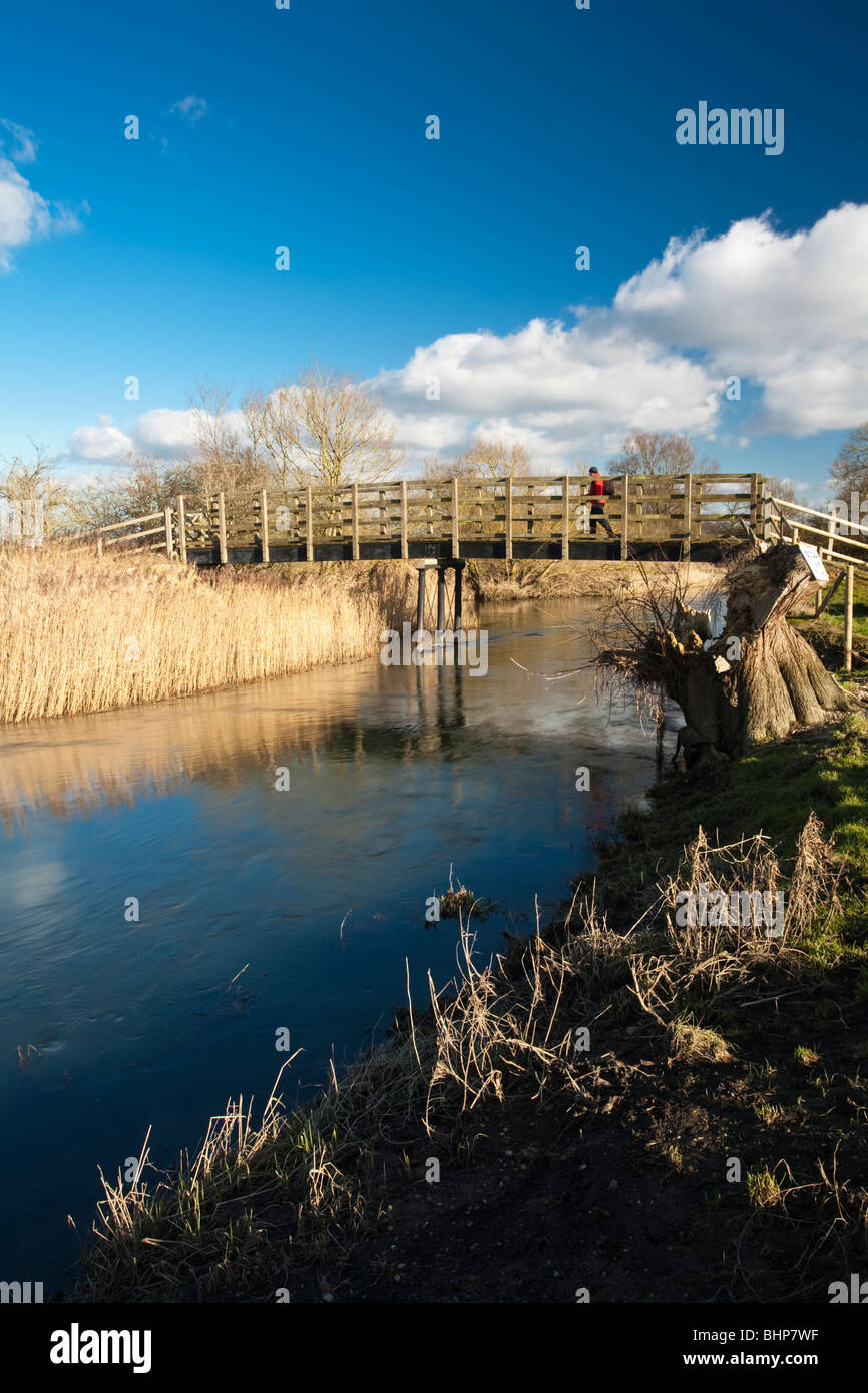 Walker crossing a wooden footbridge over the upper reaches of the River ...