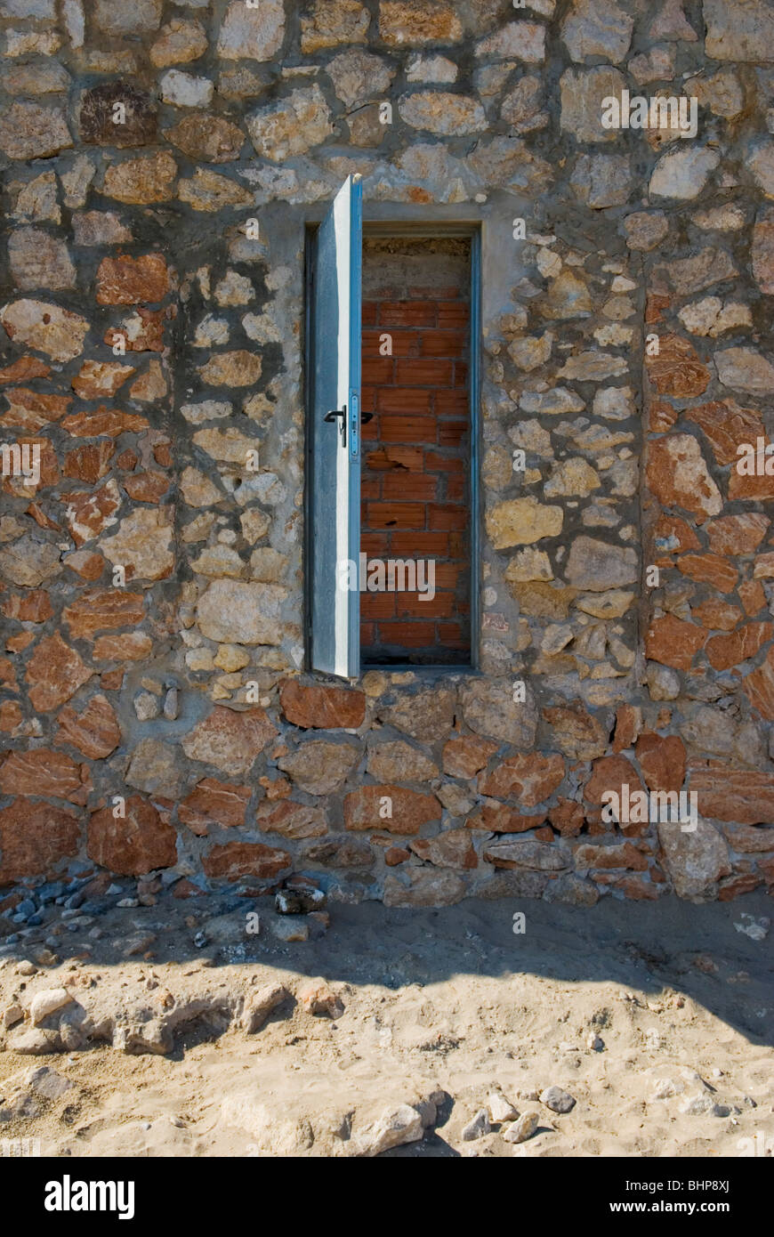 an open door, in a stone wall, reveals that it has been blocked up with ...