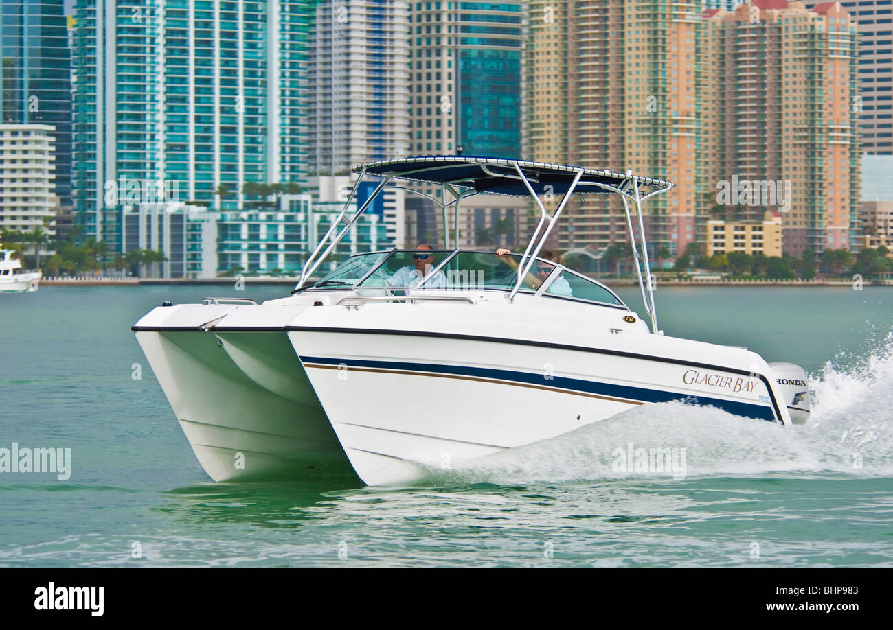 Small white Glacier Bay 2240 power catamaran with waterfront buildings ...