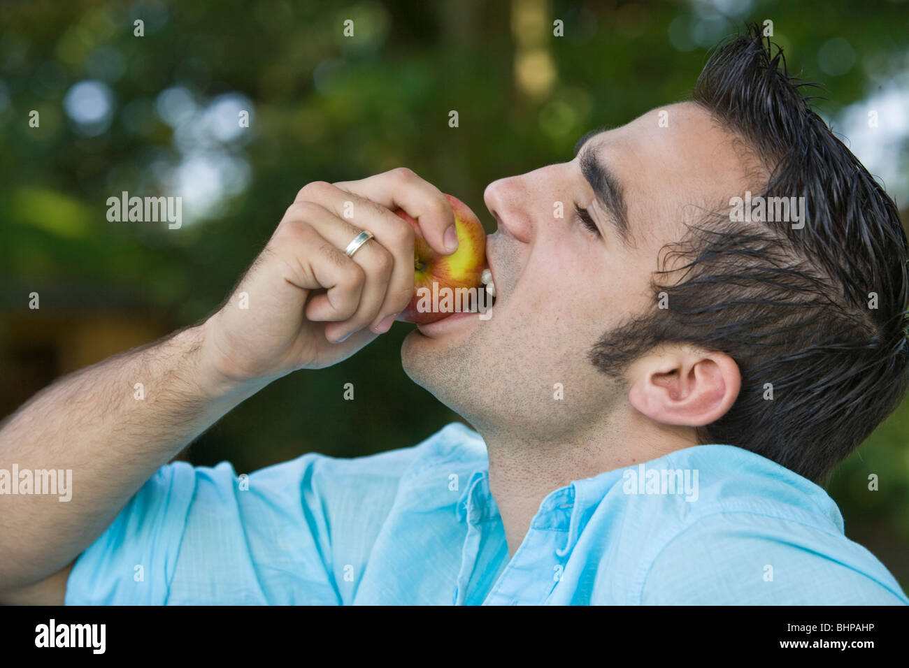 Young man eating an apple Stock Photo - Alamy