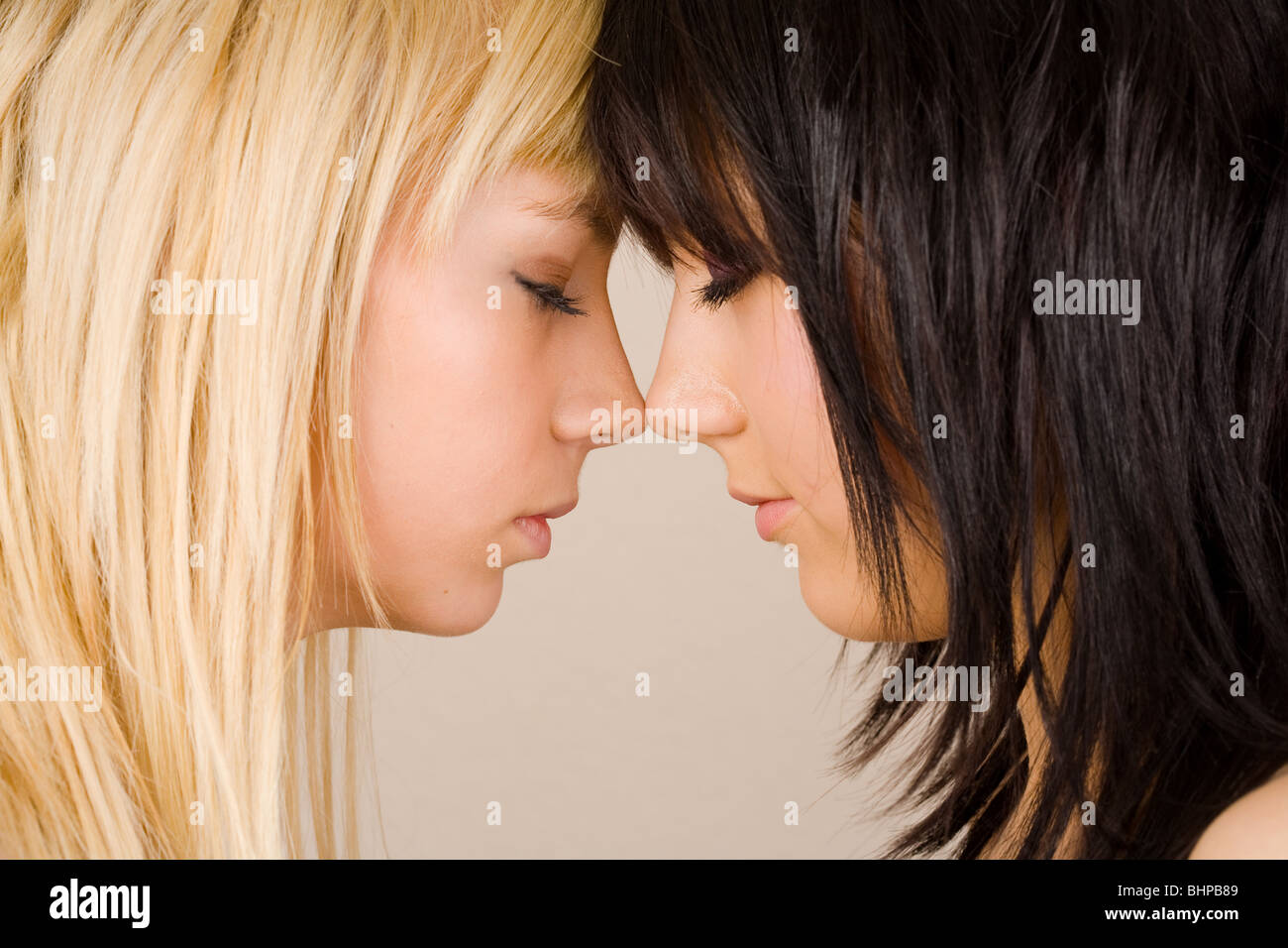 Close up portrait of two beautiful girls with opposite hair color ...