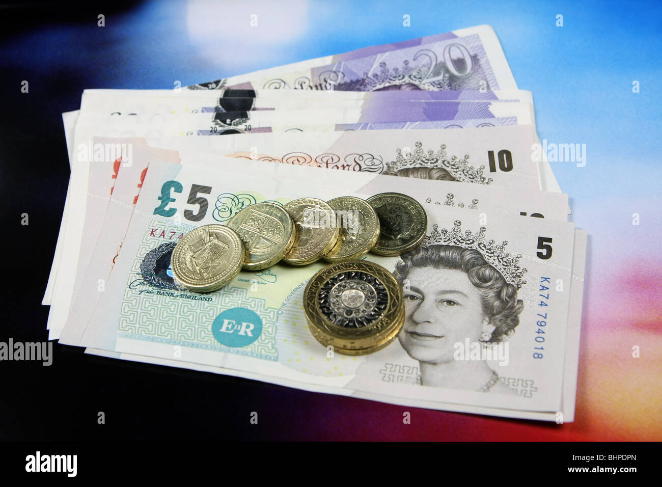 sterling notes and coins on an open book Stock Photo - Alamy