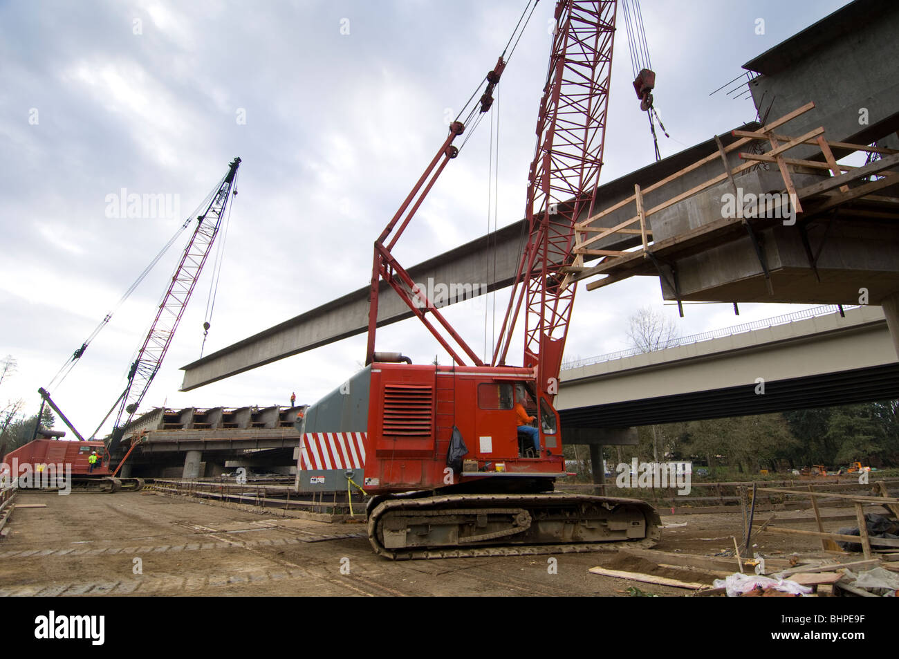 two cranes lifting steel truss for a bridge expansion Stock Photo - Alamy