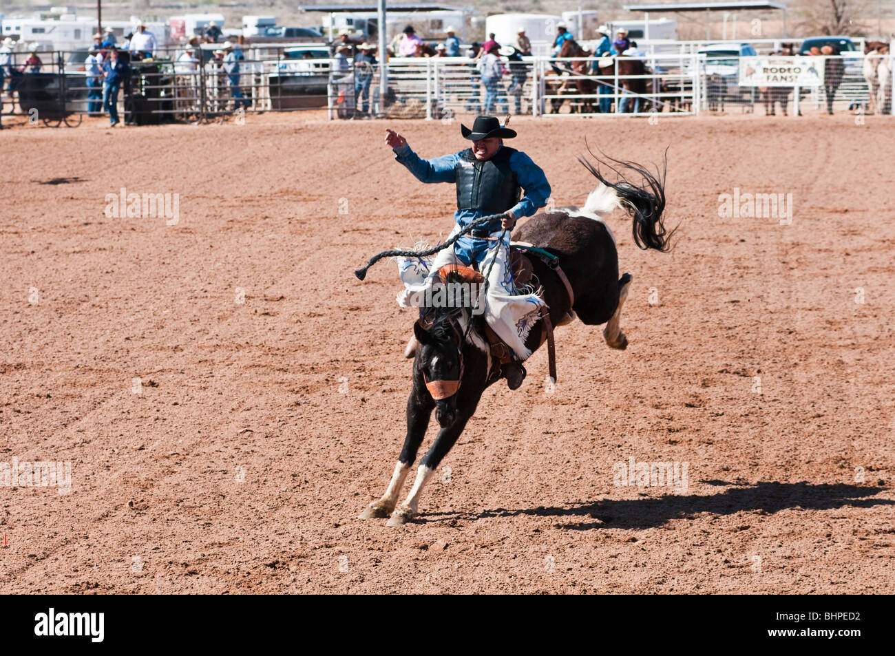 a cowboy competes in the saddle bronc riding event during the O'Odham ...
