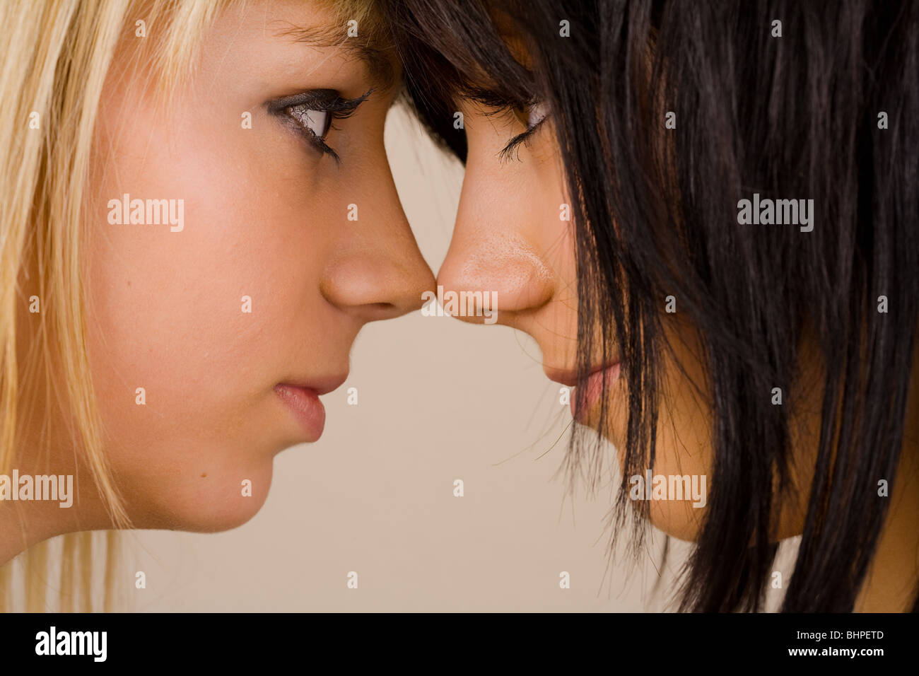 Close up portrait of two beautiful girls with opposite hair color ...