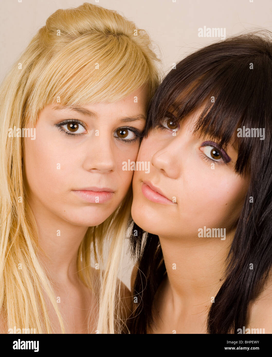 Close up portrait of two beautiful girls with opposite hair color ...